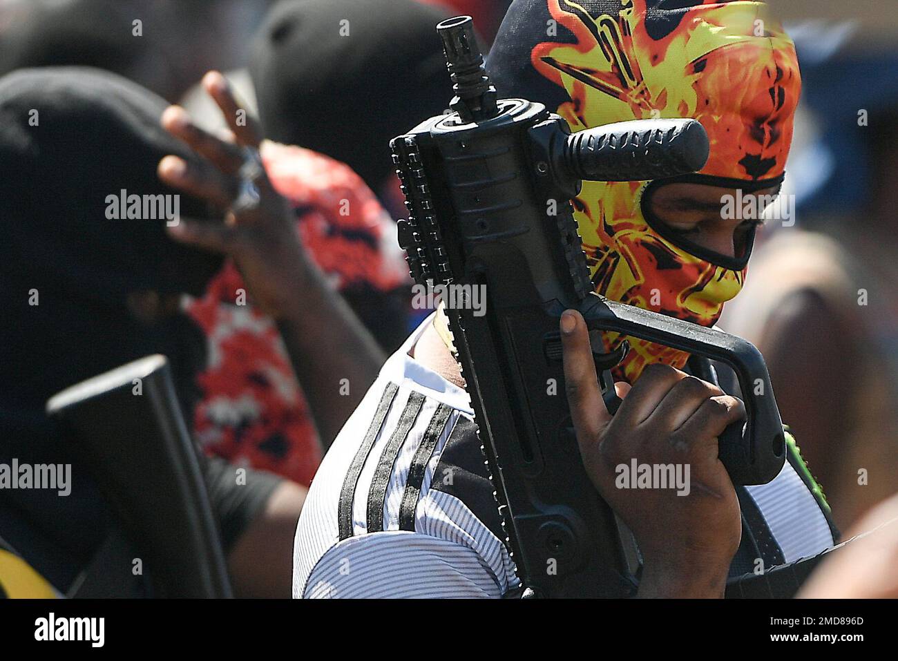 Members of the "G9 and Family" gang hold weapons as the group marches ...