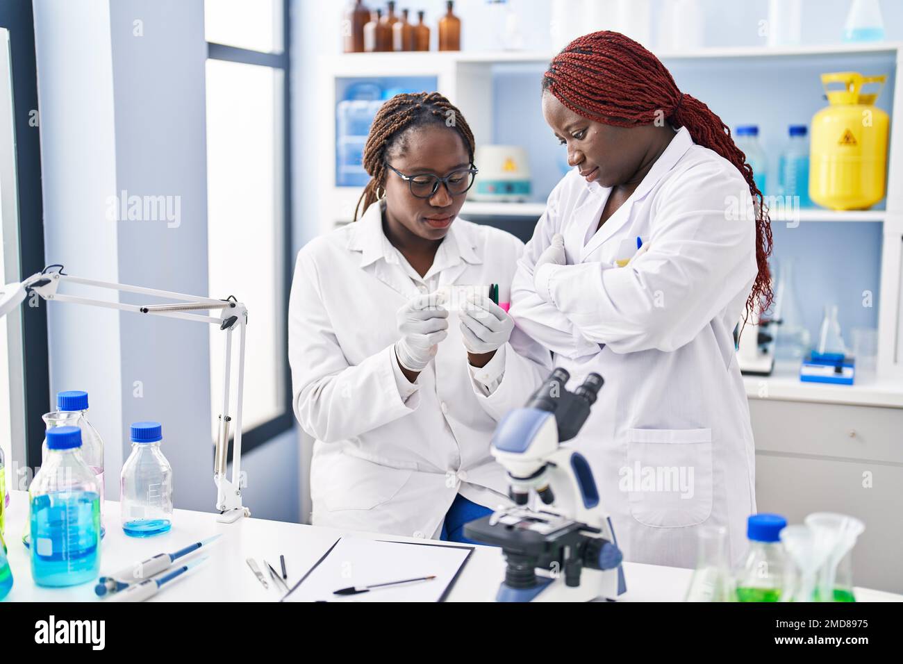 African american women scientists looking sample standing with arms ...