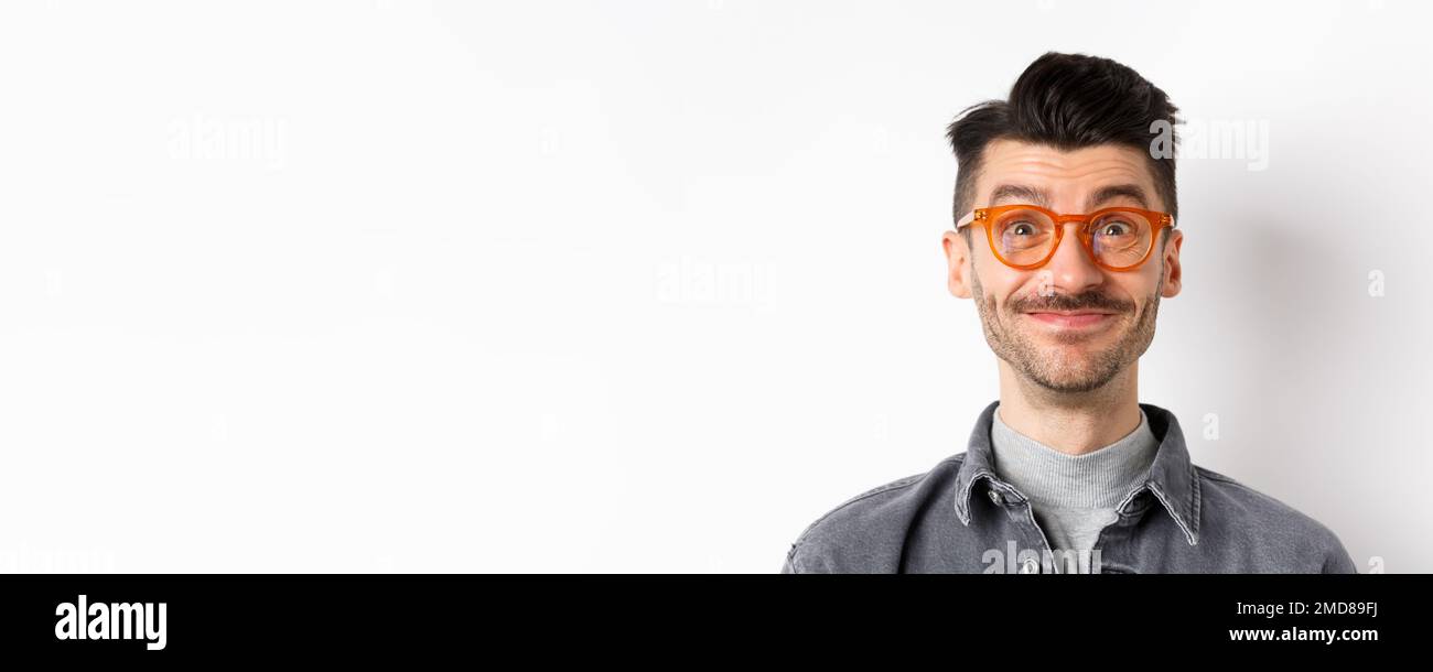 Close-up of happy man with moustache and glasses looking at camera ...