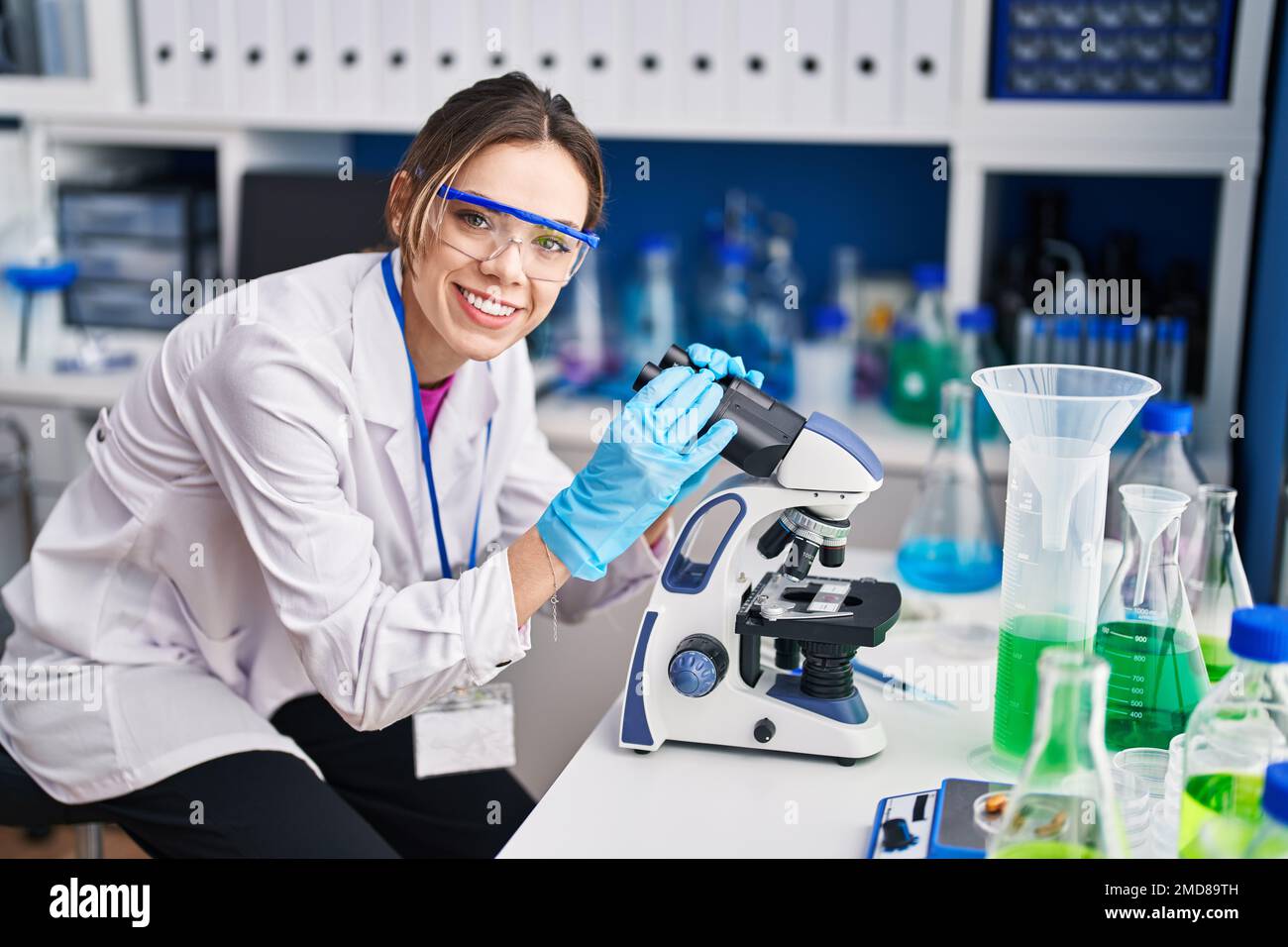 Young beautiful hispanic woman scientist using microscope at laboratory Stock Photo - Alamy