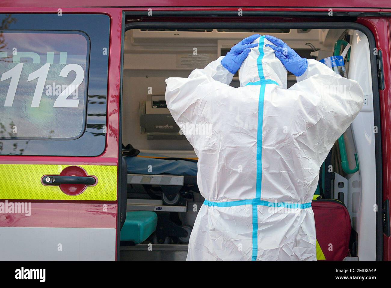 A paramedic adjusts his protection equipment outside the University ...