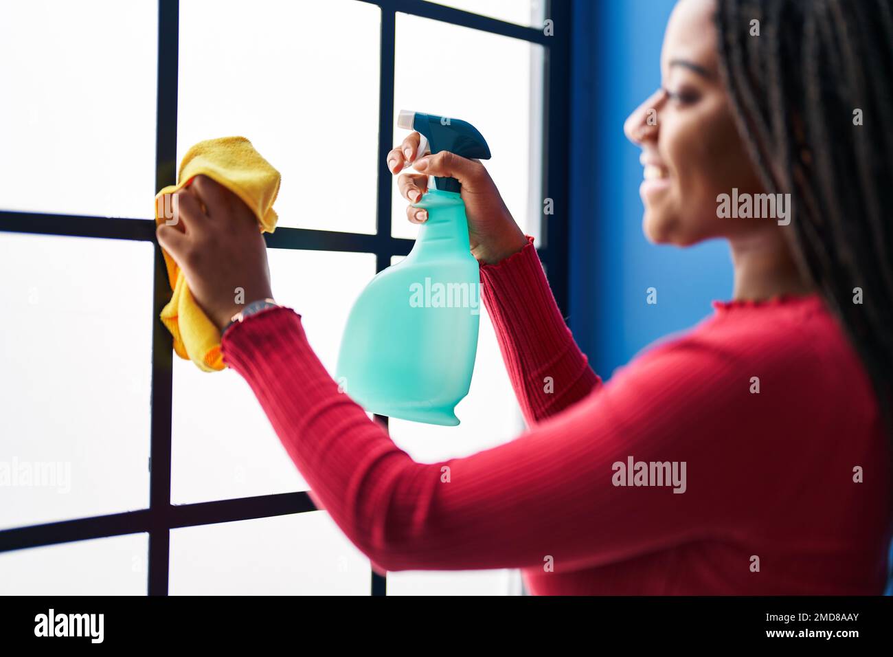African american woman smiling confident cleaning window at home Stock ...