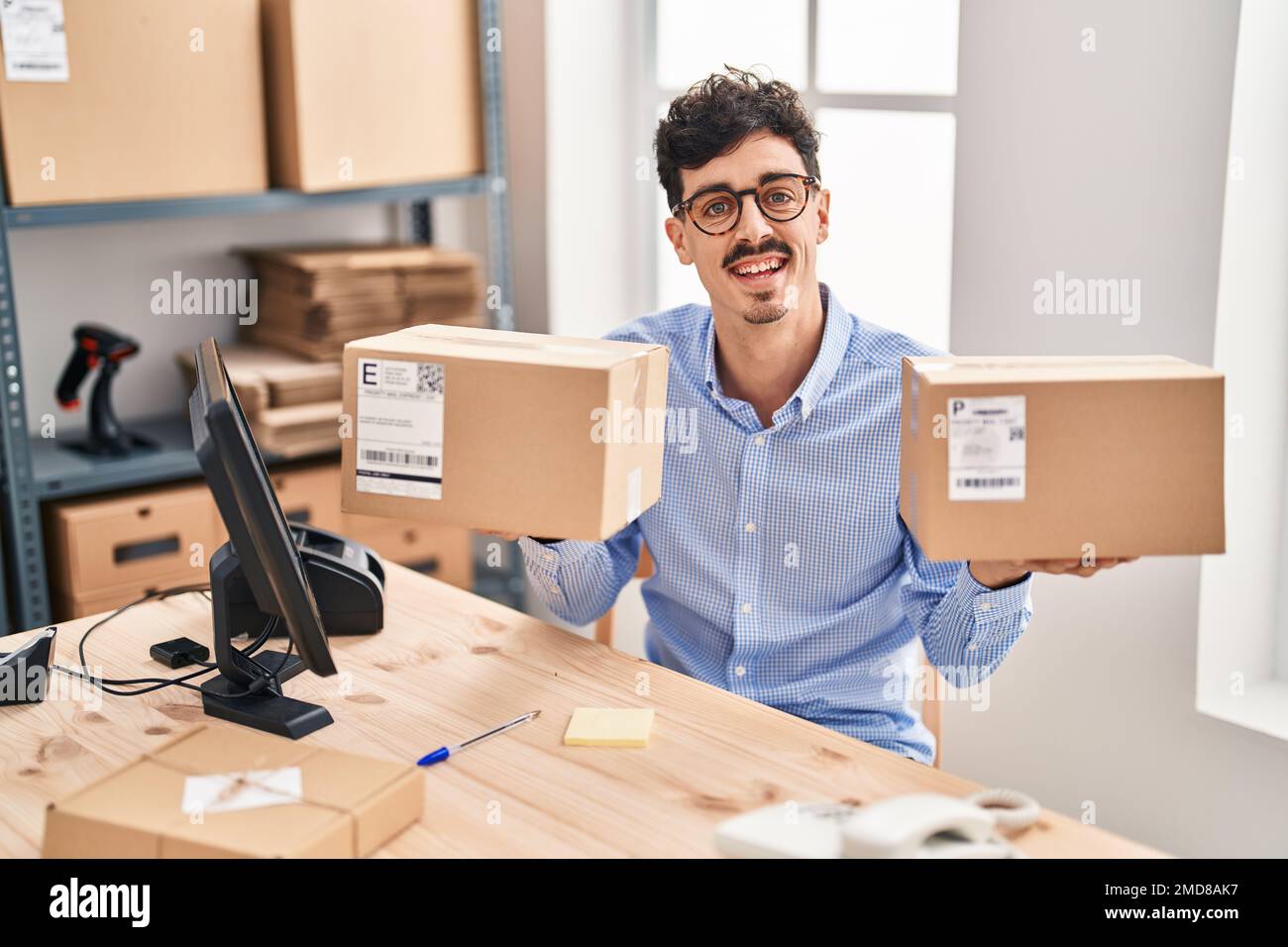 Hispanic man working at small business ecommerce holding packages ...