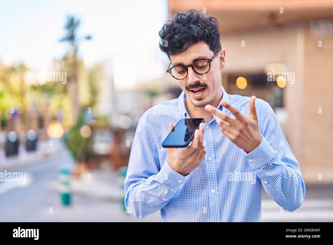 Young caucasian man talking on the smartphone with serious expression ...