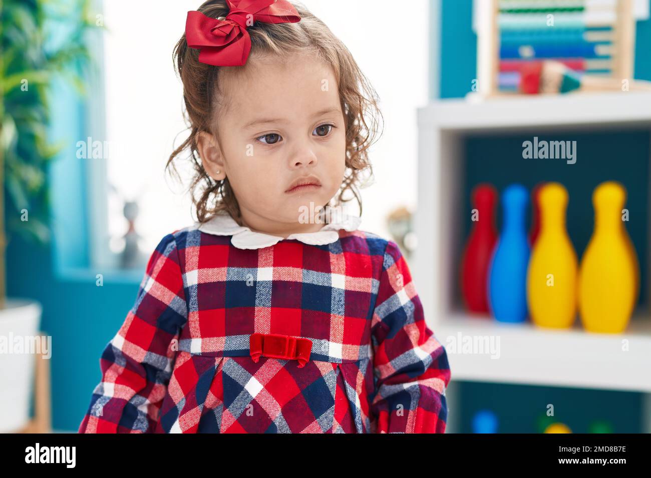Adorable blonde toddler standing with serious expression at ...