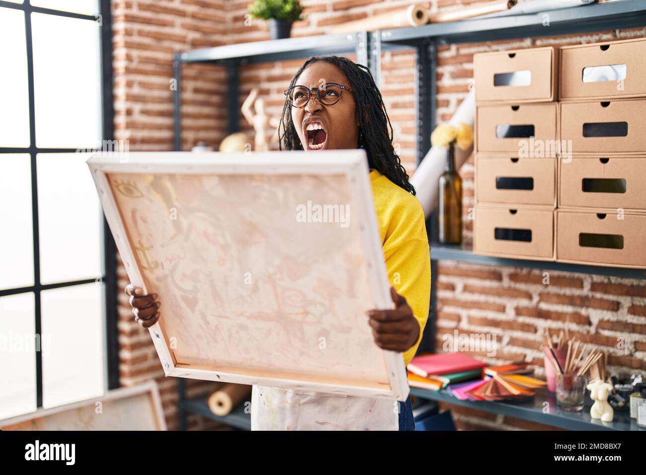 African woman looking at painter canvas angry and mad screaming ...