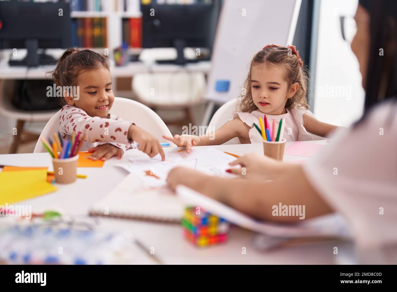 Two kids preschool students sitting on table drawing on paper at ...