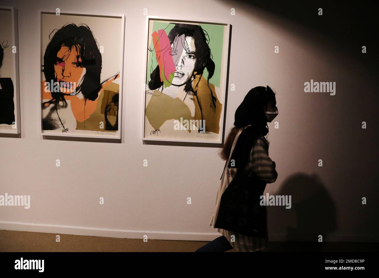 A visitor walks past Mick Jagger portrait series by American artist ...