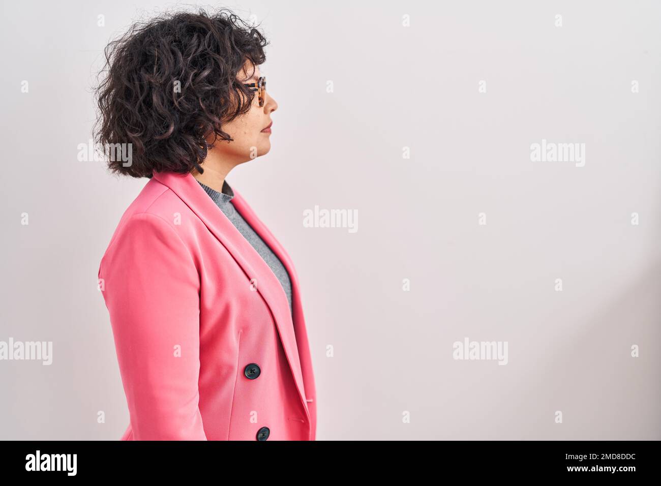 Hispanic woman with curly hair standing over isolated background ...