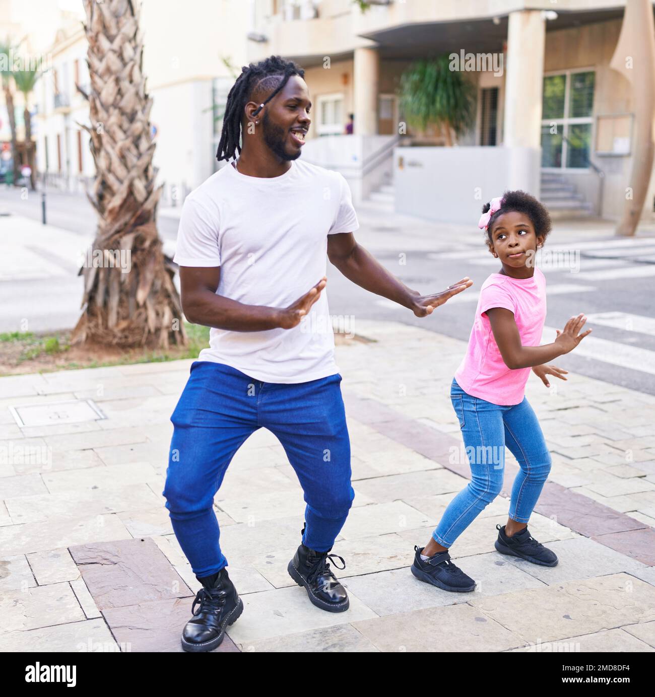Father and daughter smiling confident dancing together at street Stock ...