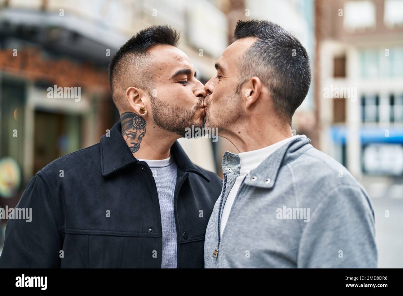 Two men couple hugging each other kissing at street Stock Photo - Alamy