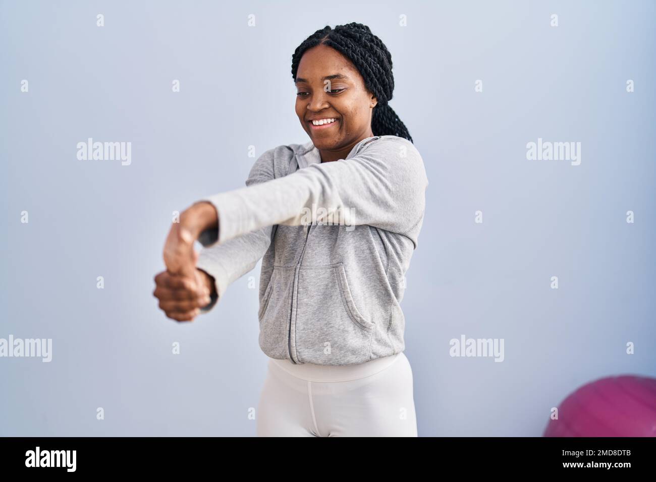 African american woman smiling confident stretching arm at sport center ...