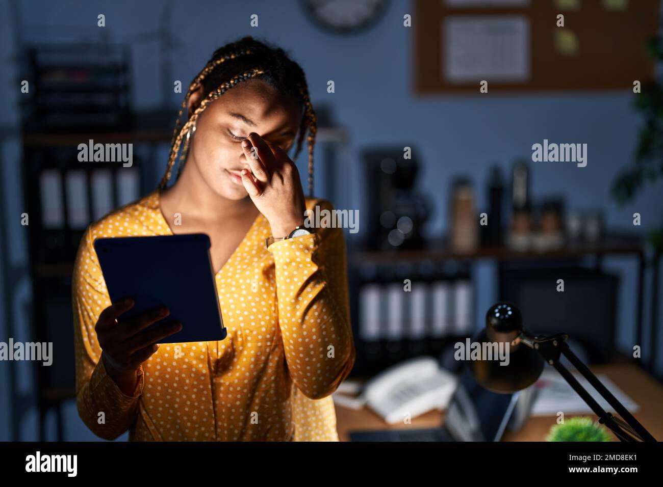 African american woman with braids working at the office at night with ...