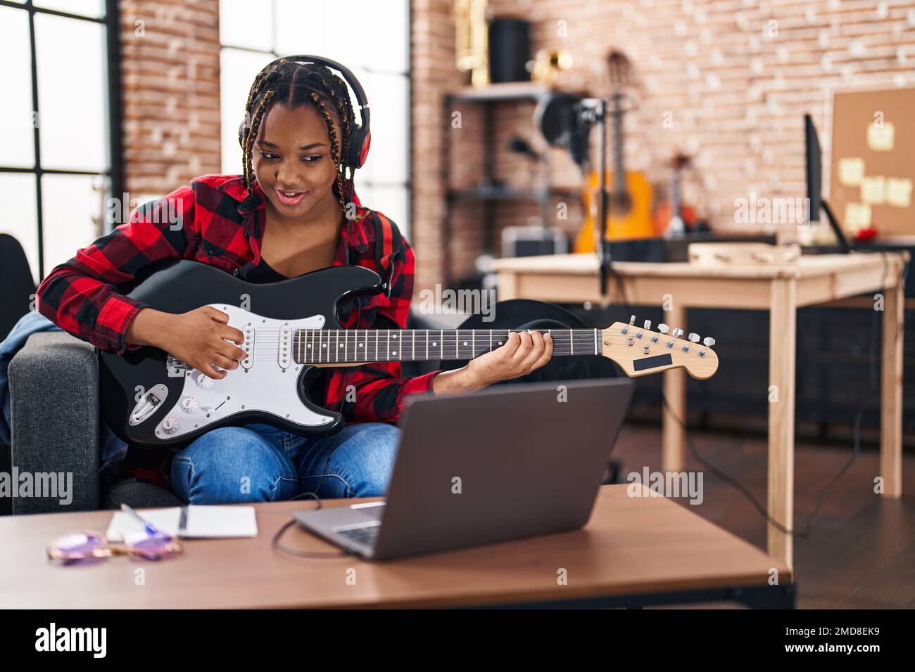 African american woman musician having online electrical guitar lesson ...