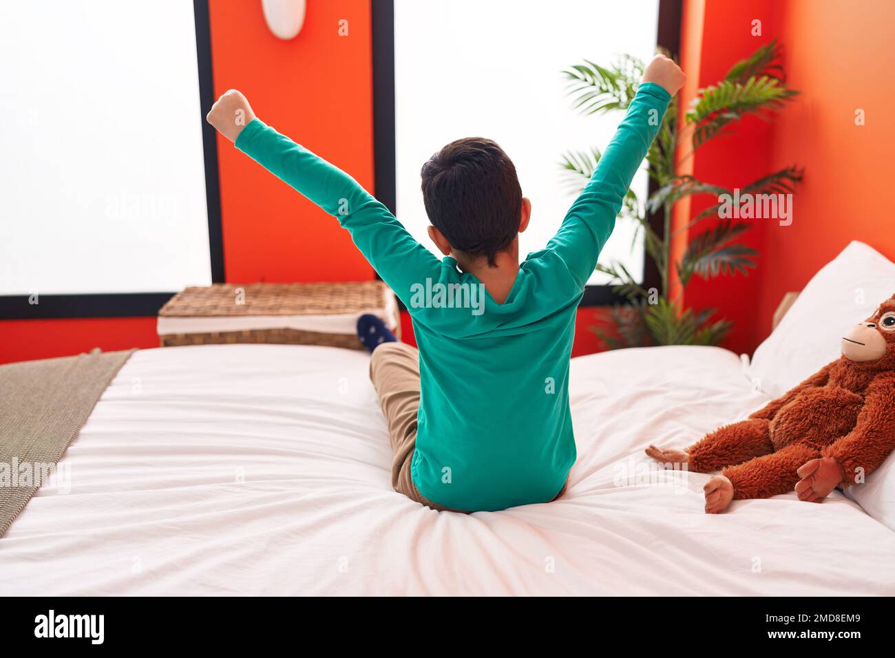 Adorable hispanic boy waking up stretching arms at bedroom Stock Photo ...