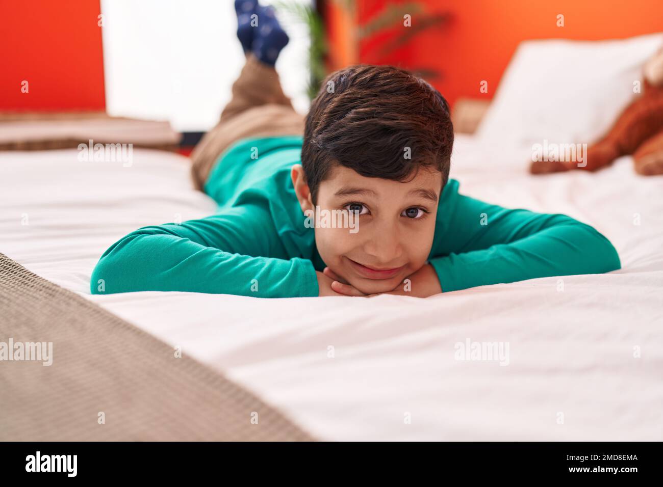 Adorable hispanic boy smiling confident lying on bed at bedroom Stock ...