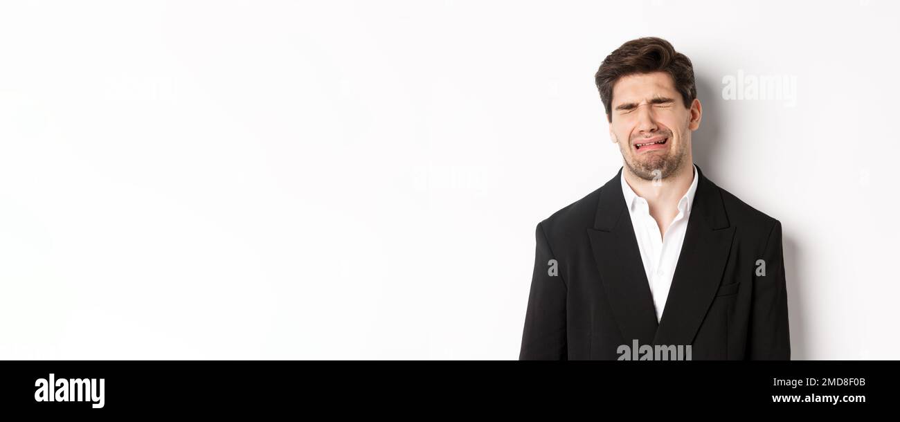 Close-up of miserable man in suit, crying and sobbing, feeling sad ...