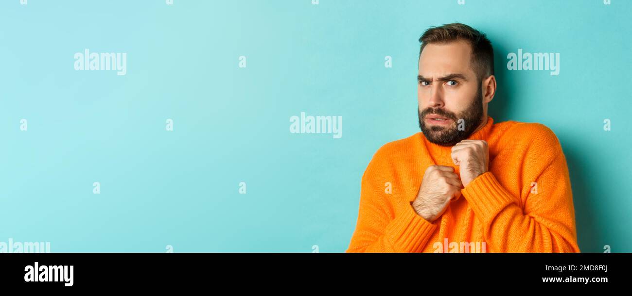 Close-up of scared bearded man looking startled and displeased, jumping ...