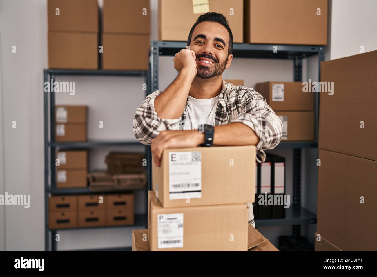 Young hispanic man ecommerce business worker leaning on packages at ...