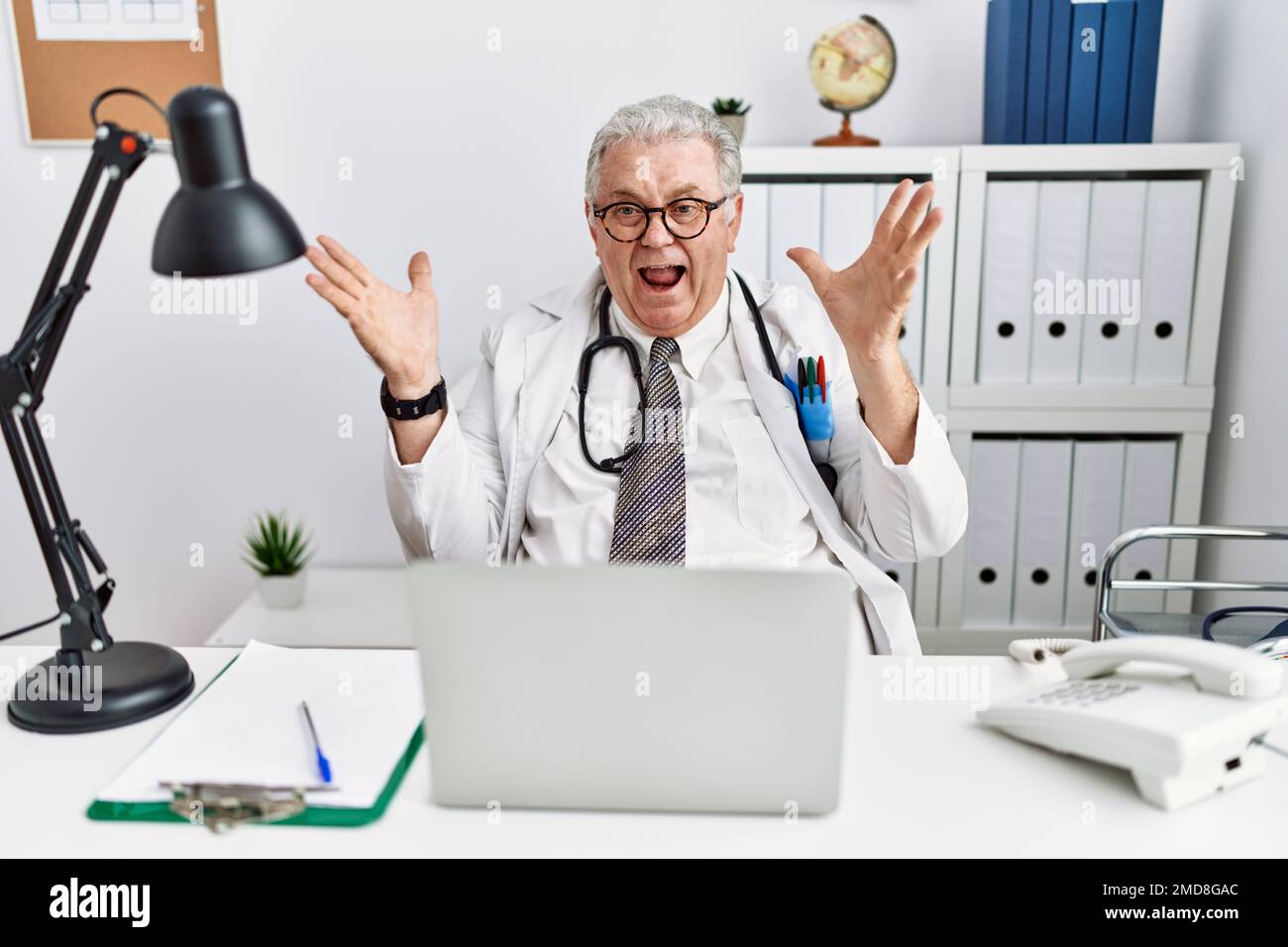 Senior caucasian man wearing doctor uniform and stethoscope at the ...