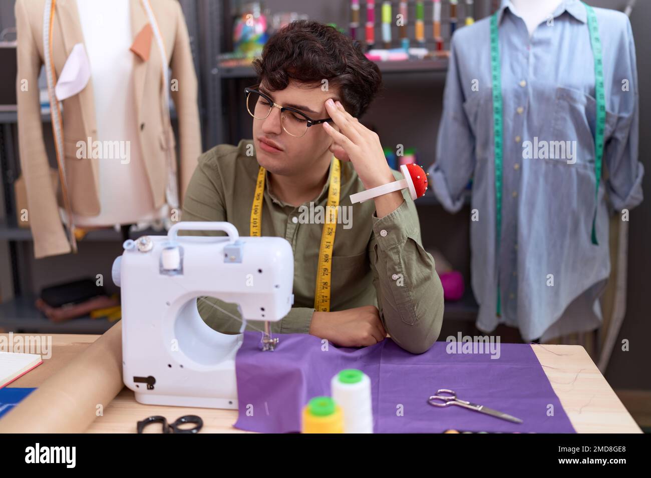 Non binary man tailor stressed using sewing machine suffering for ... Non binary man tailor stressed using sewing machine suffering for ...