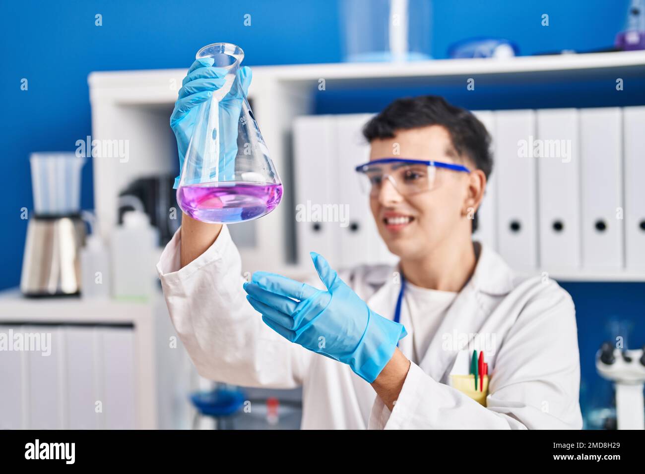 Young non binary man scientist smiling confident measuring liquid at laboratory Stock Photo - Alamy