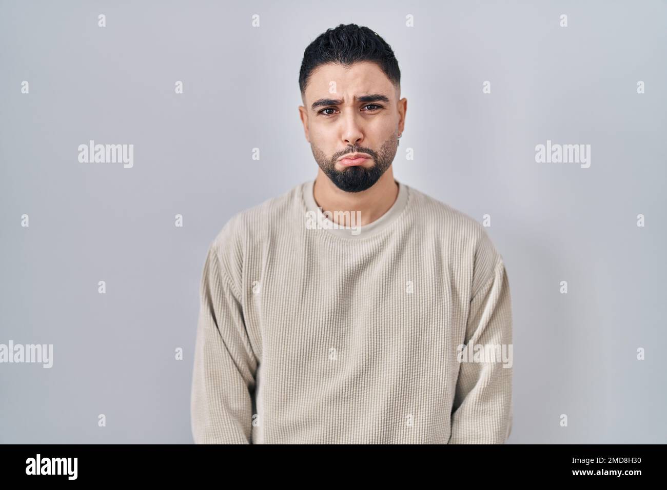 Young handsome man standing over isolated background depressed and ...