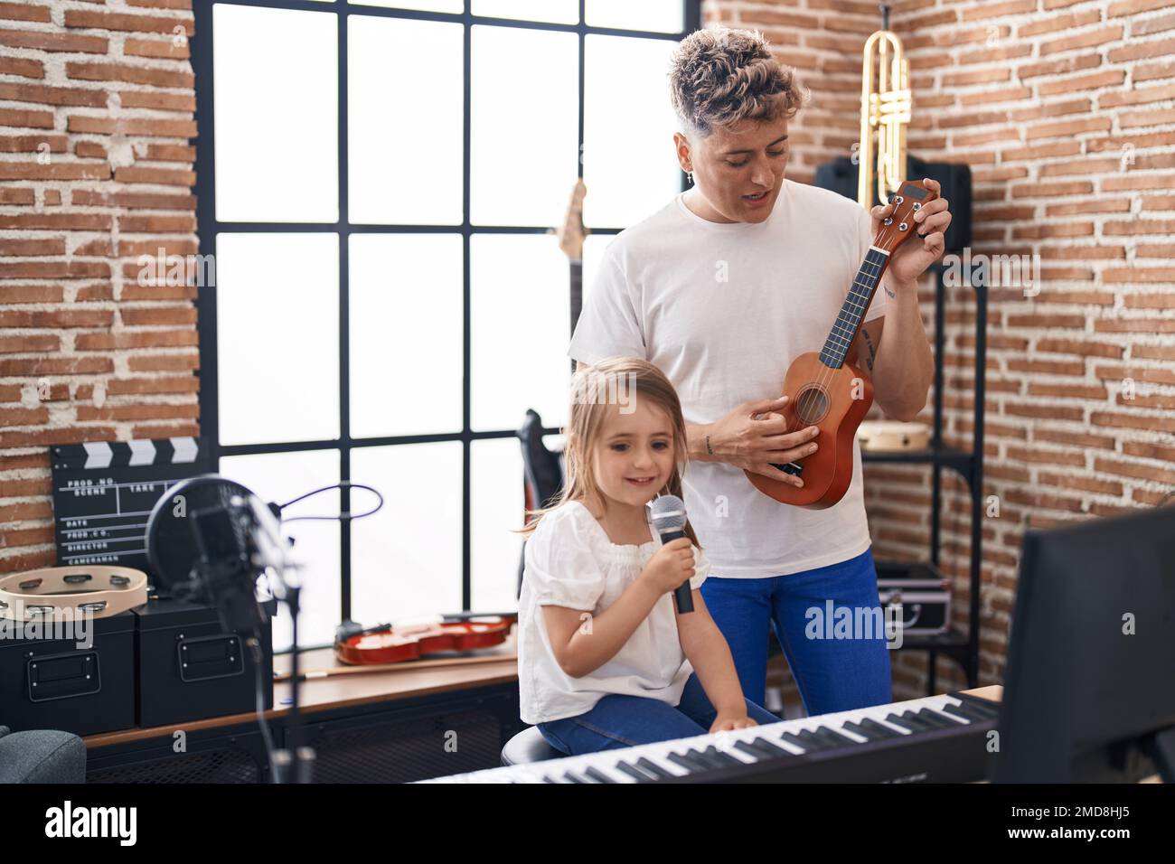 Father and daughter singing song playing ukulele at music studio Stock ...