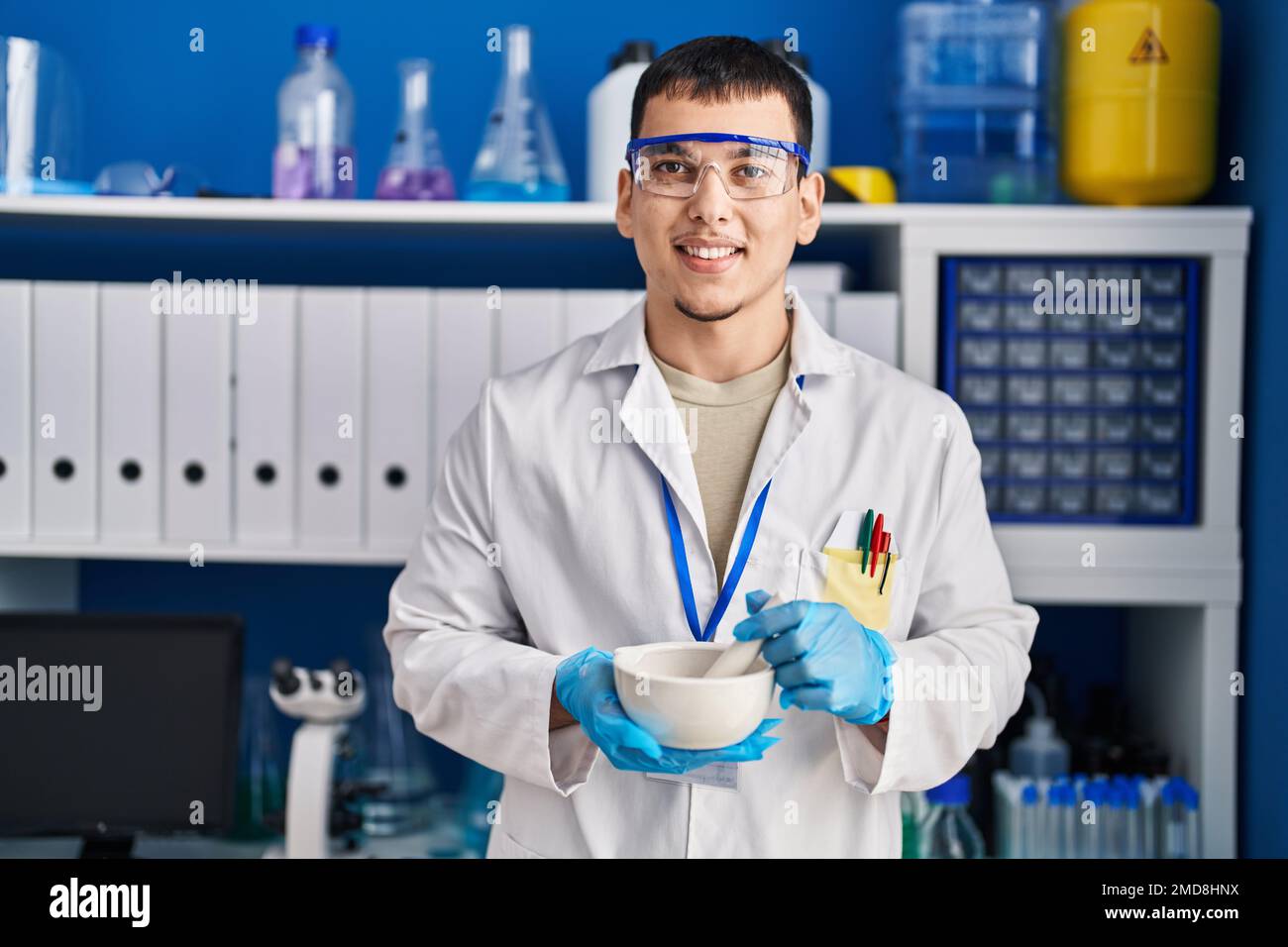 Young arab man working at scientist laboratory smiling with a happy and ...