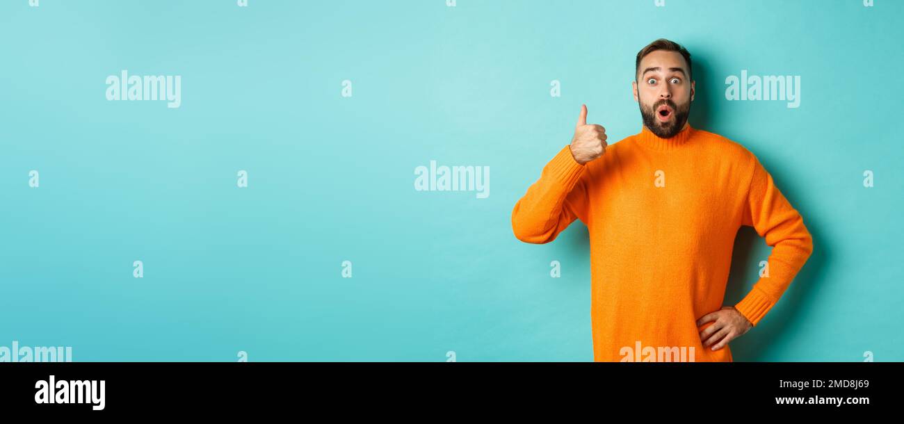 Well done. Handsome bearded man showing thumb up, praising good work ...