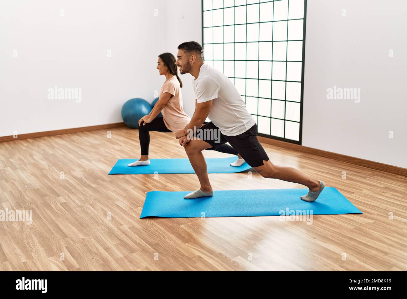 Latin man and woman couple smiling confident stretching at sport center ...