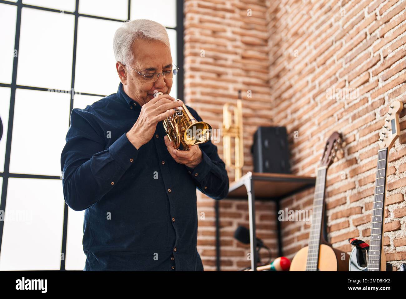 Senior man musician playing trumpet at music studio Stock Photo - Alamy