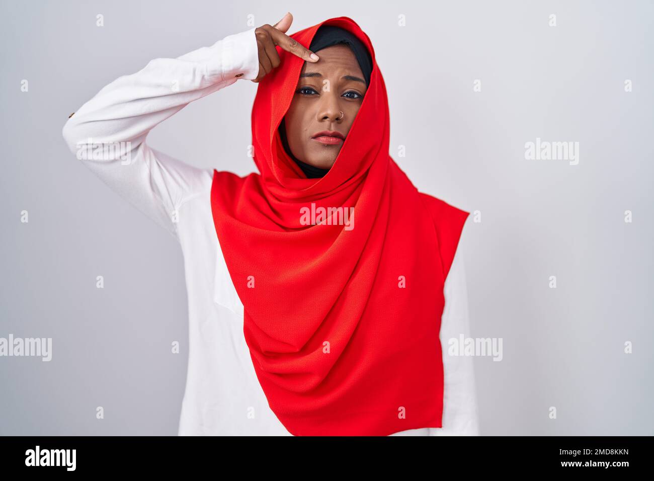 Young arab woman wearing traditional islamic hijab scarf pointing ...