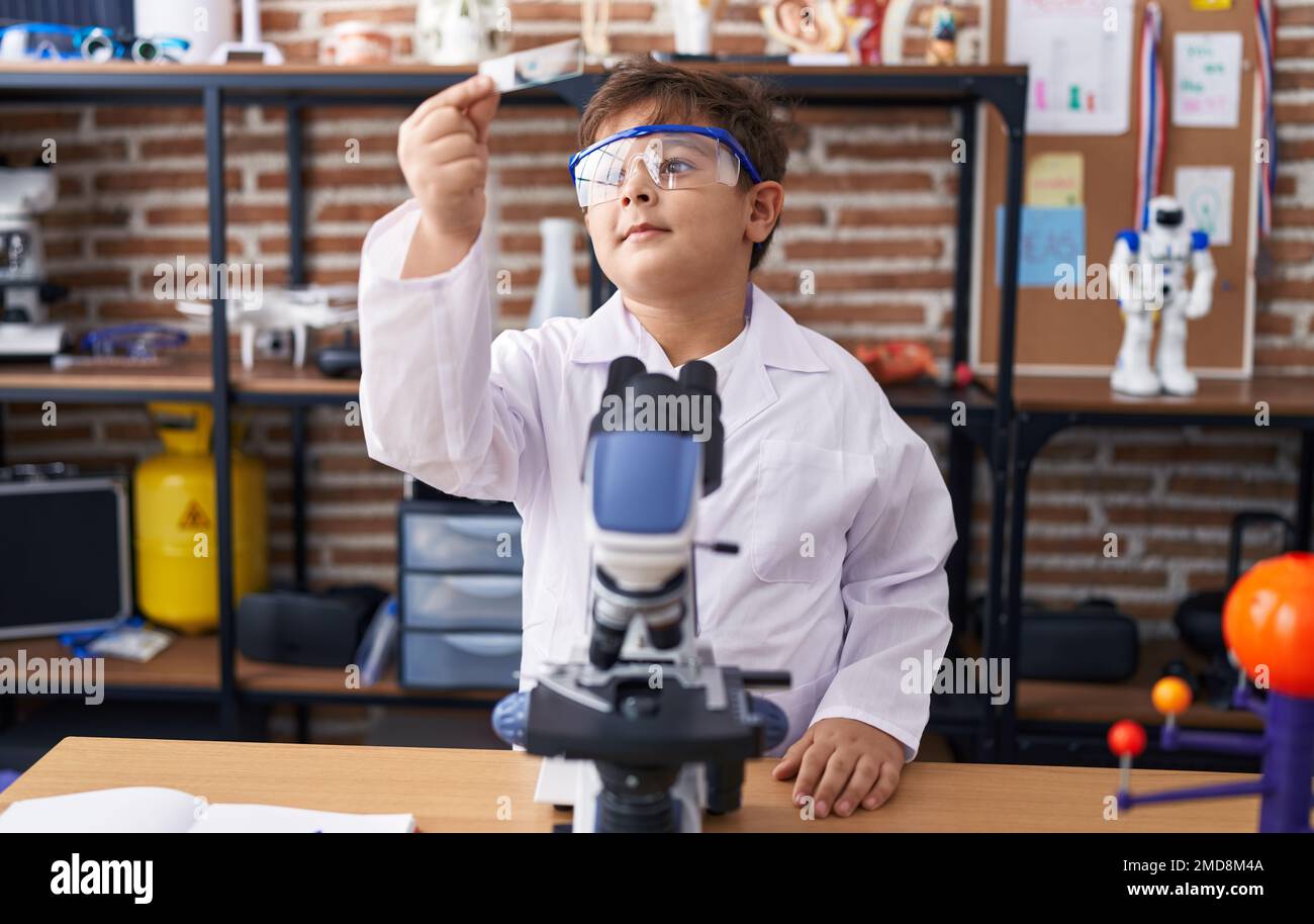 Adorable hispanic boy student smiling confident looking sample at ...