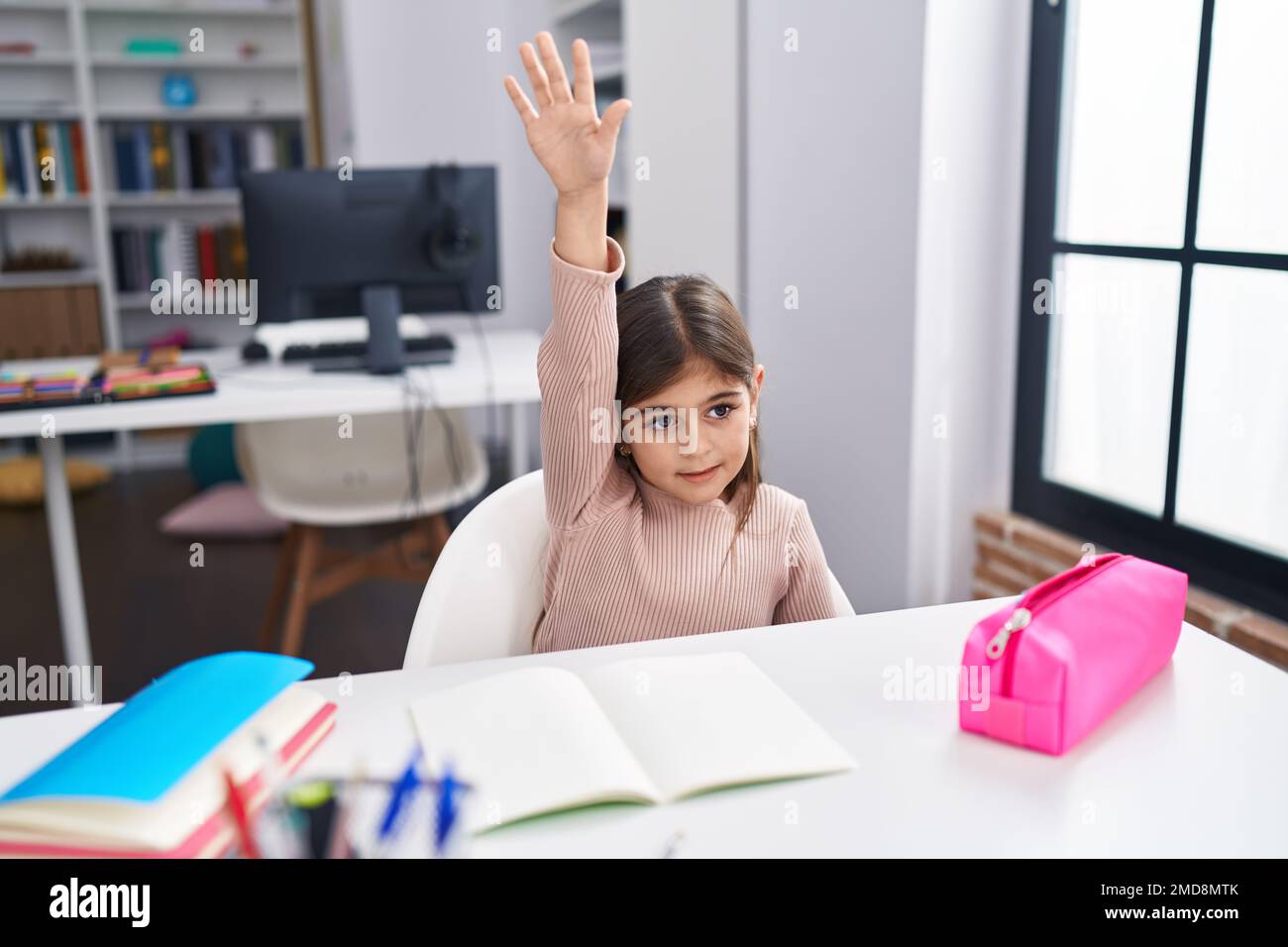 Adorable hispanic girl student having lesson with hand raised up at ...