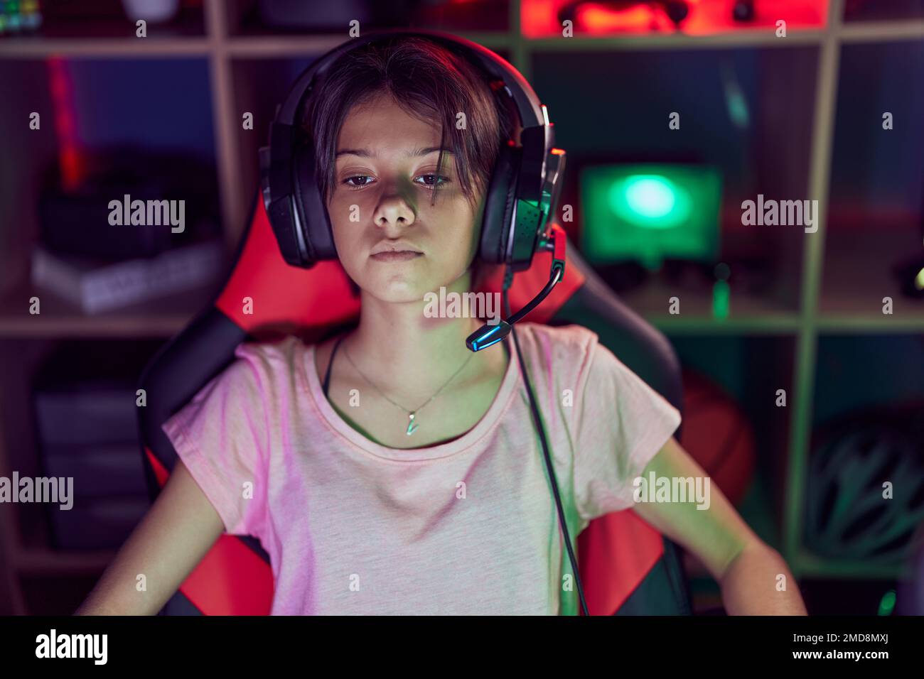 Adorable hispanic girl streamer sitting on table with serious ...