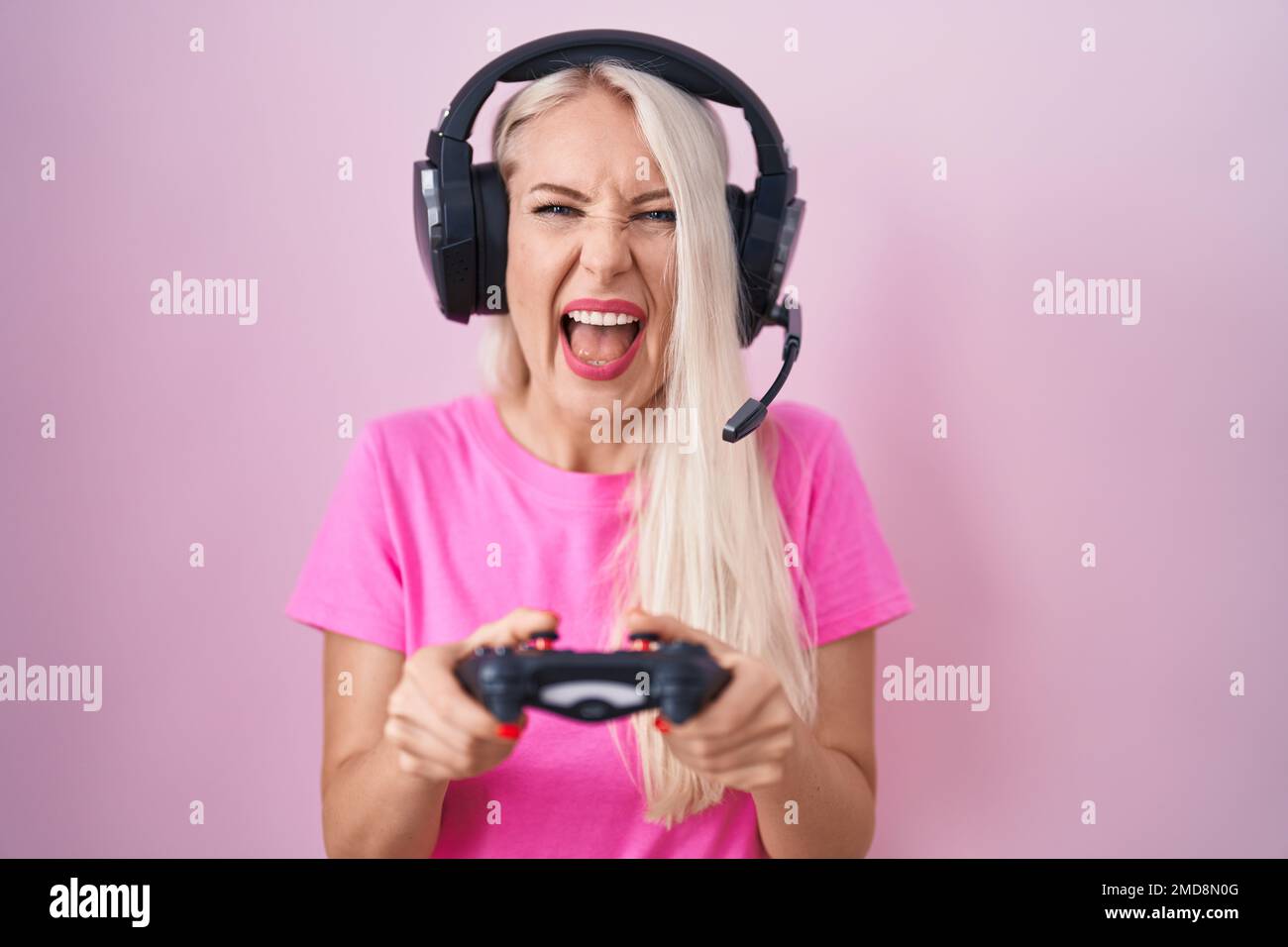 Caucasian woman playing video game holding controller angry and mad ...
