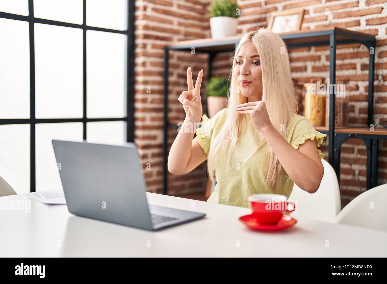Young blonde woman having video call using deaf language at home Stock ...