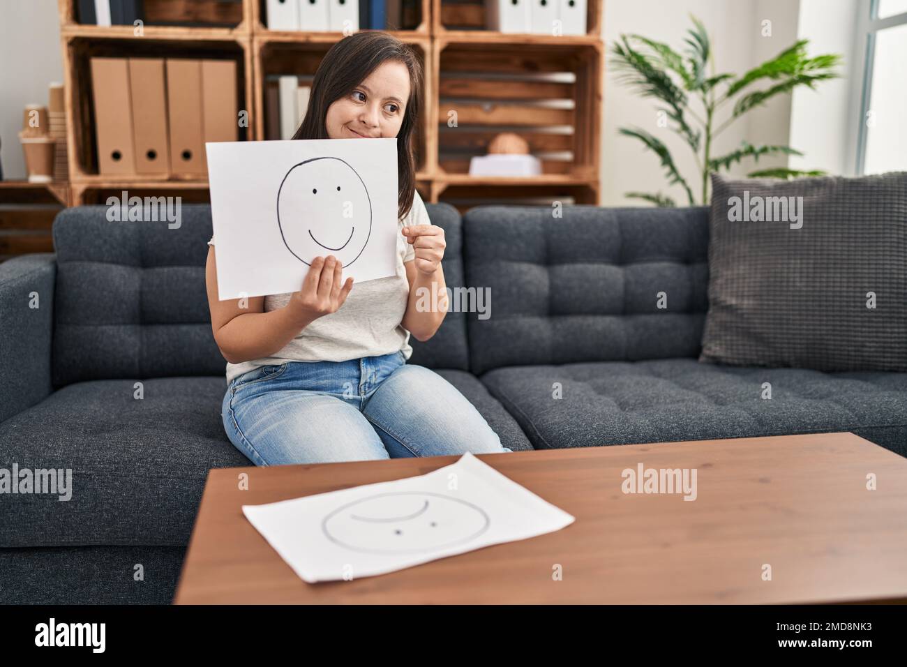 Down syndrome woman patient having psychology session pointing to happy ...