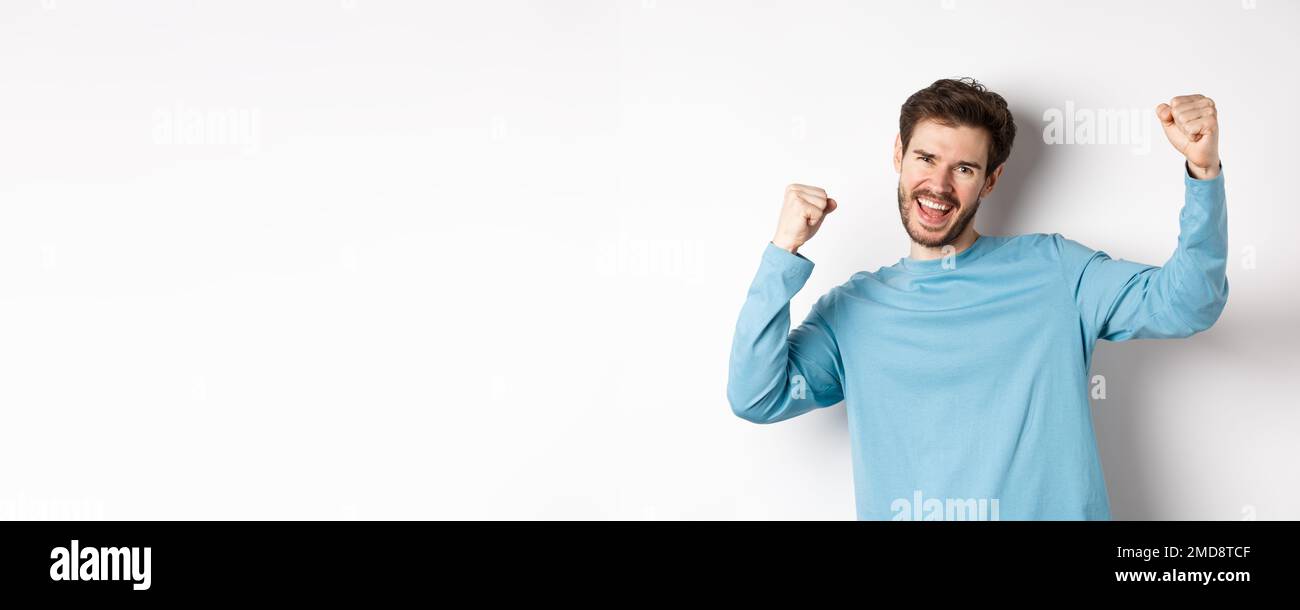 Image of happy young man triumphing, feeling like champion, winning and ...