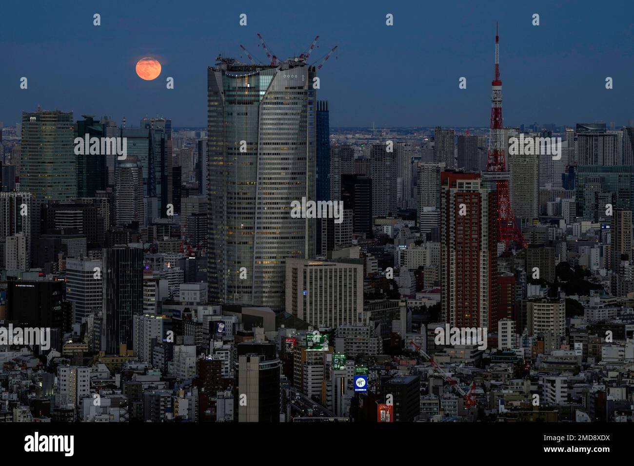 The full moon rises above the Tokyo skyline Wednesday, Oct. 20, 2021 ...