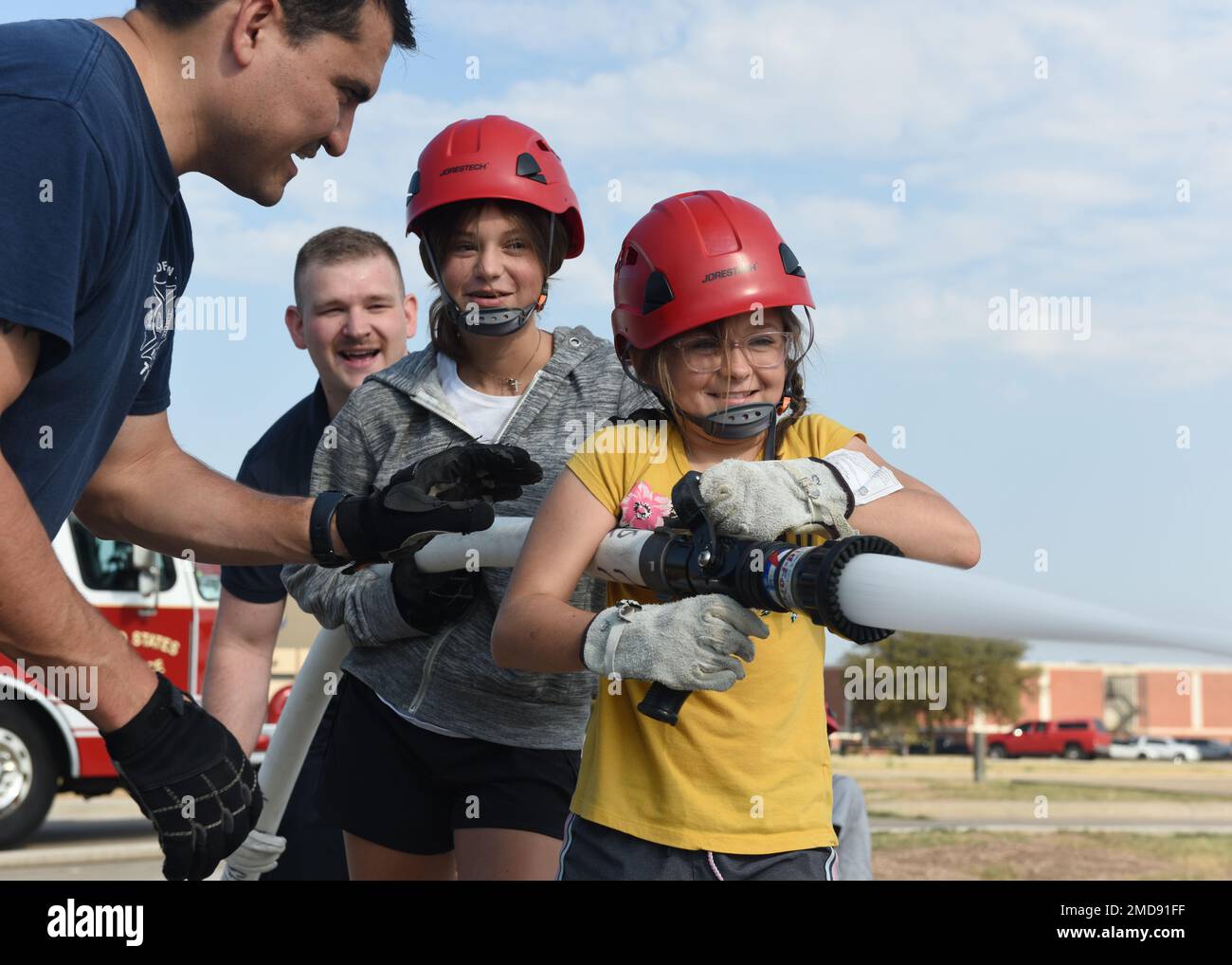 Paige and Karsyn Ramsdell, junior firefighter camp students, operate a fire hose during the fire ...