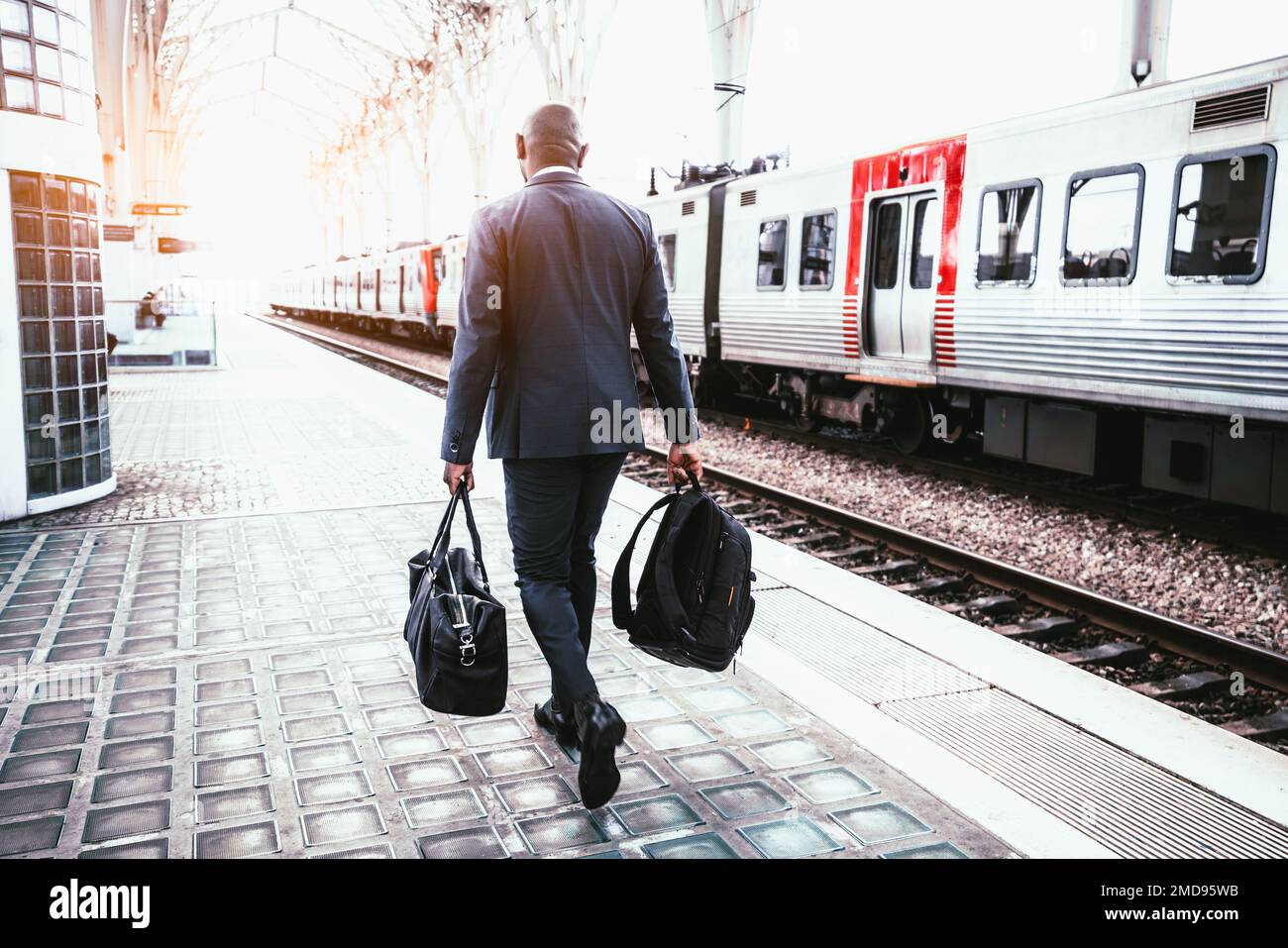 A backshot of a bald black elegant man well-dressed in a dark full-body ...