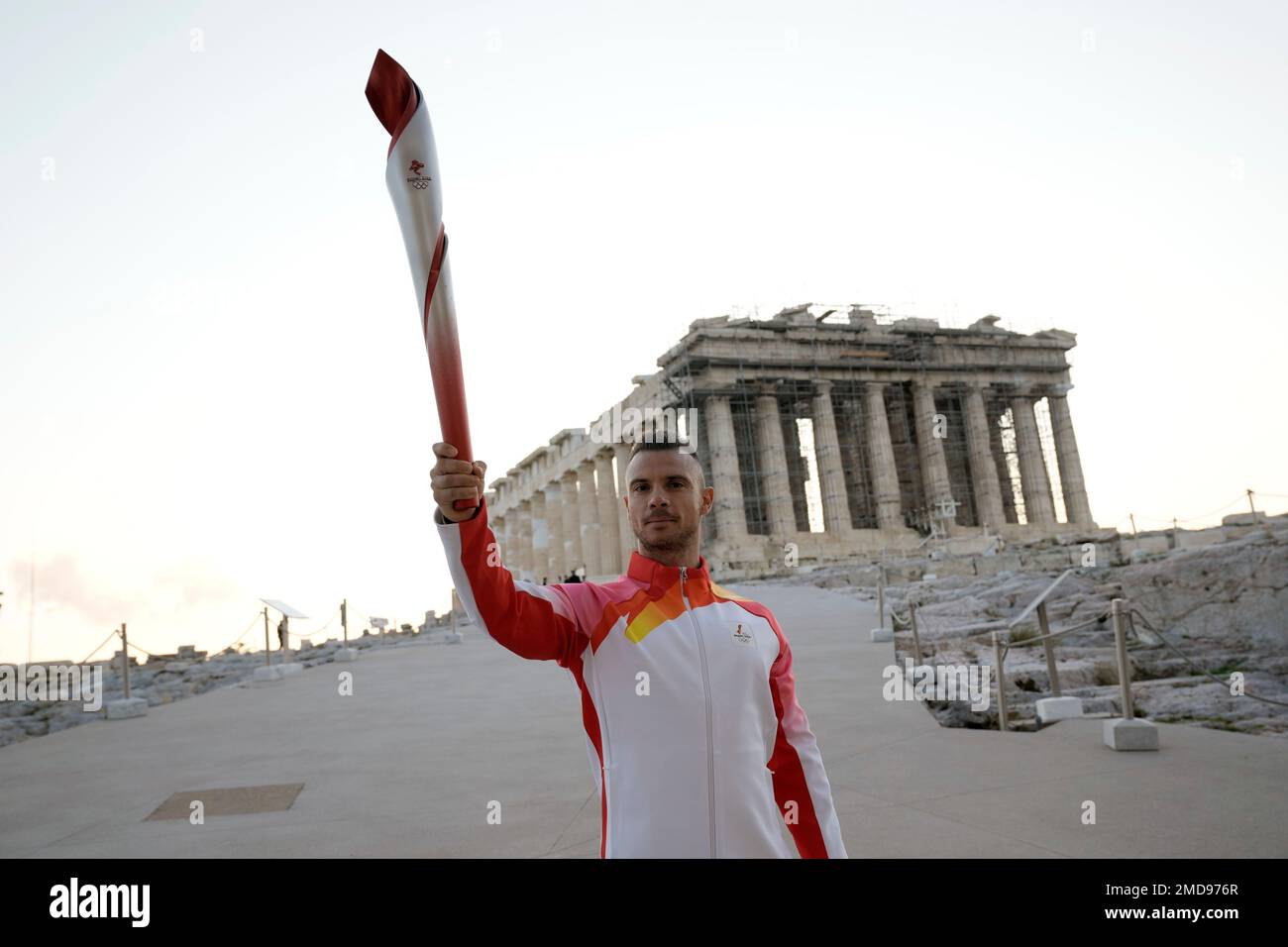 Greek torch bearer Christos Volikakis, world Champion in Cycling, holds ...