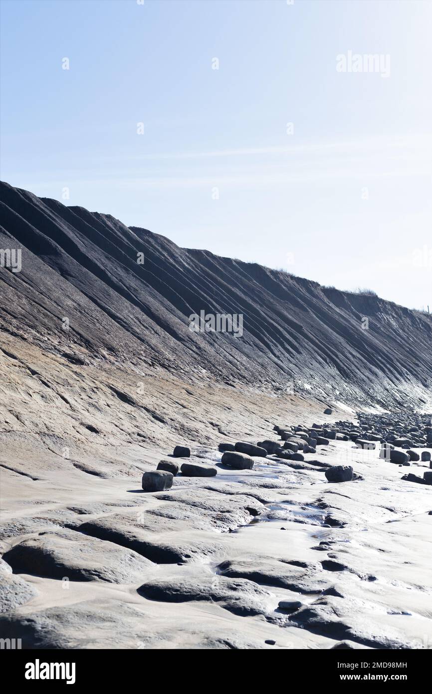Large rocks below a ledge, on a beach in central Oregon Stock Photo - Alamy