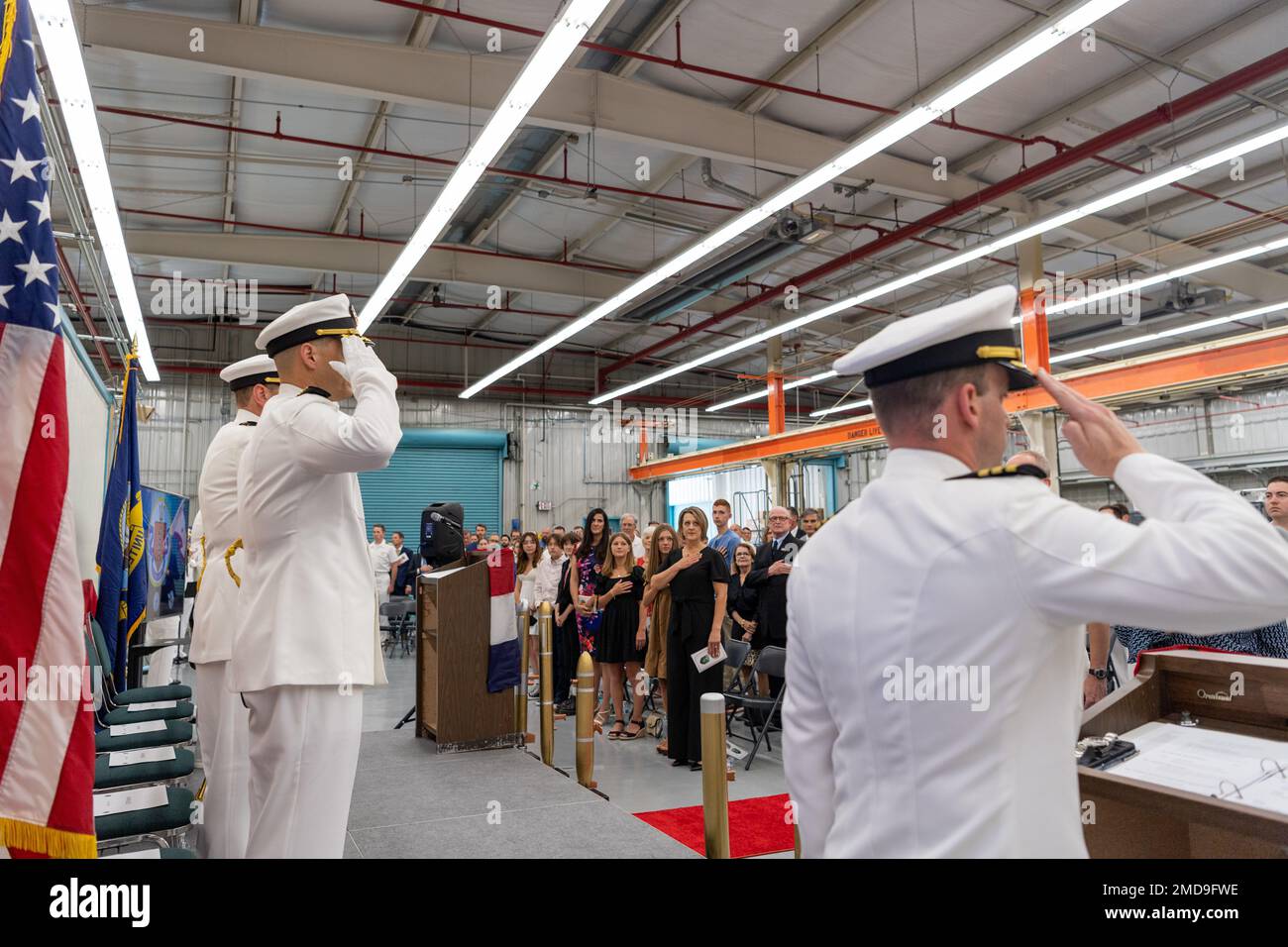 Leadership and guests render honors during the National Anthem at a ceremony held to elevate ...