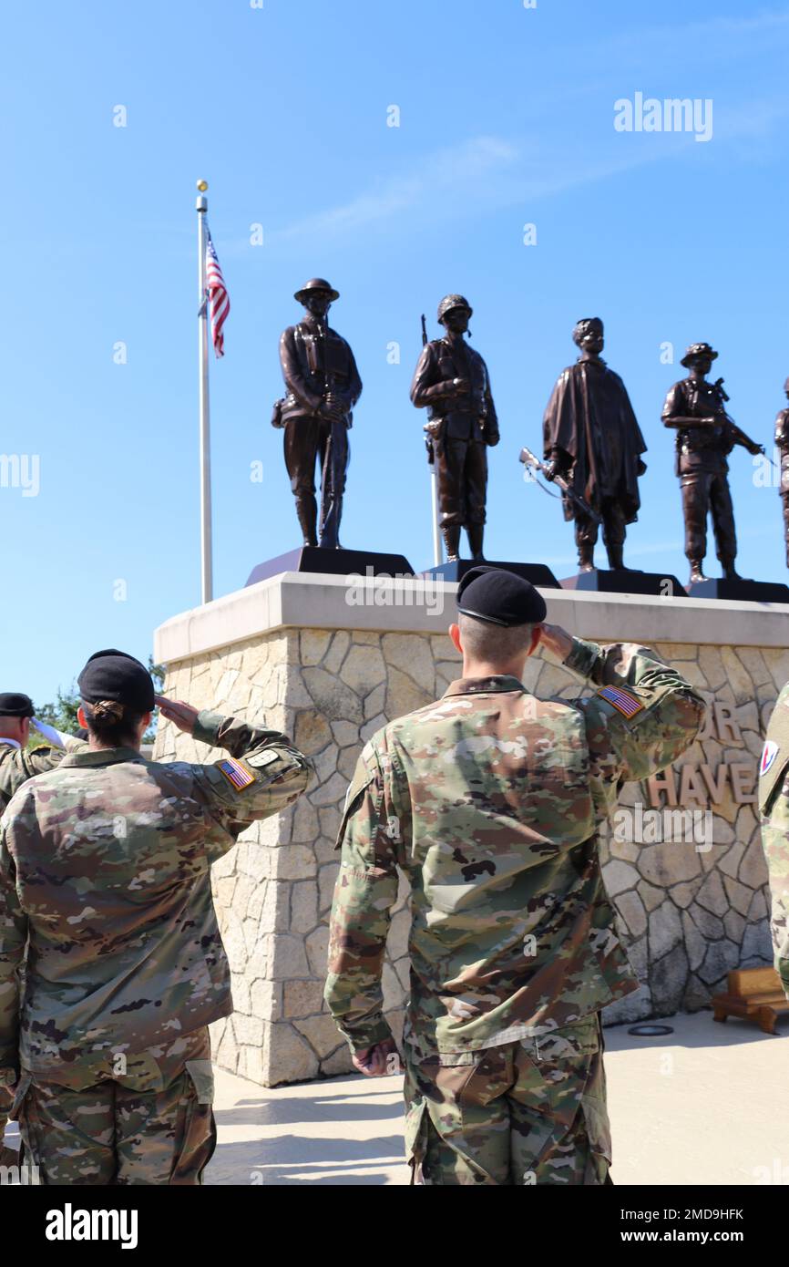 Members of the official party salute as the national anthem is played ...