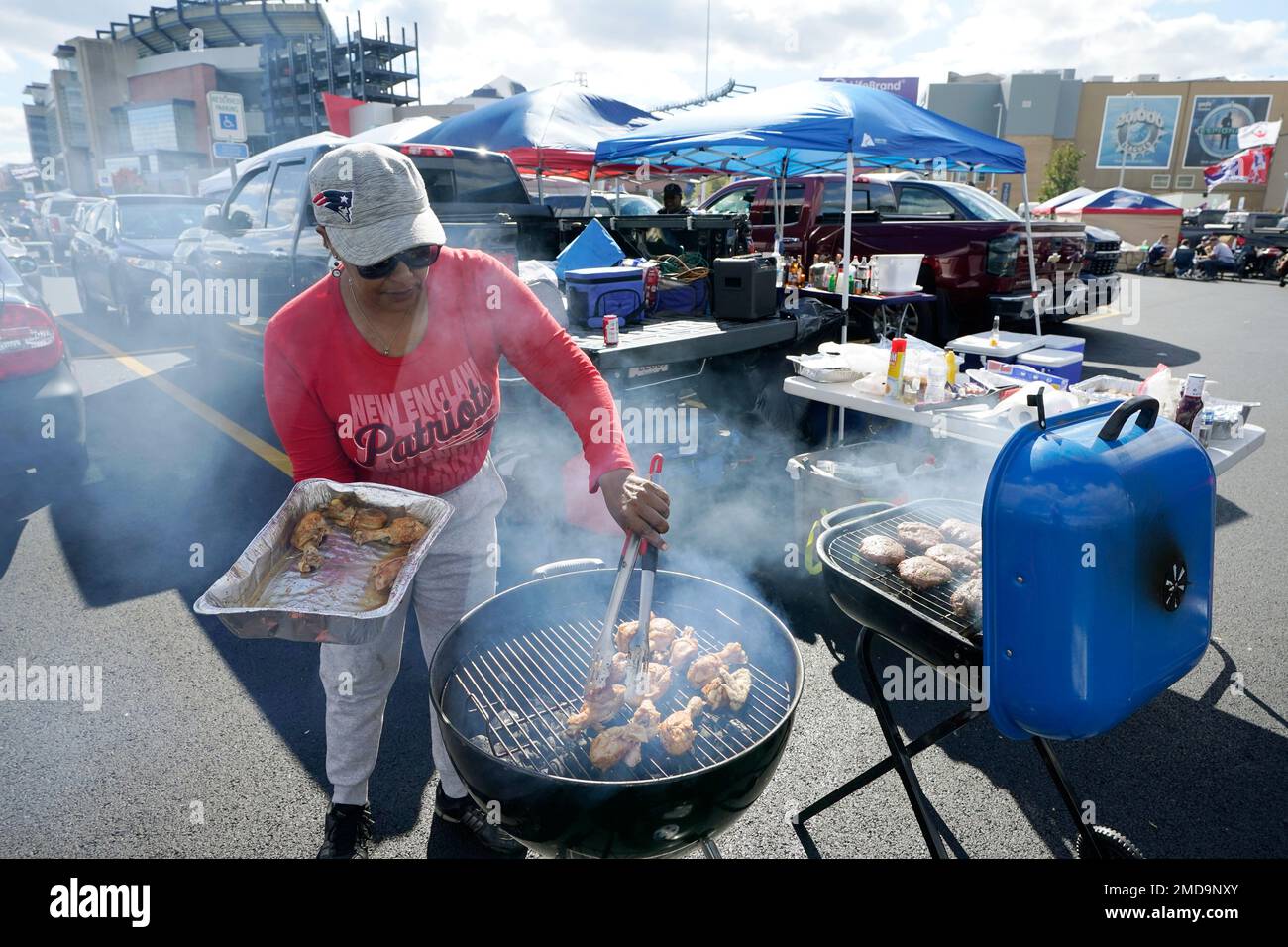 Leila Bryant, of Norwood, Mass. grills wings prior to an NFL football ...