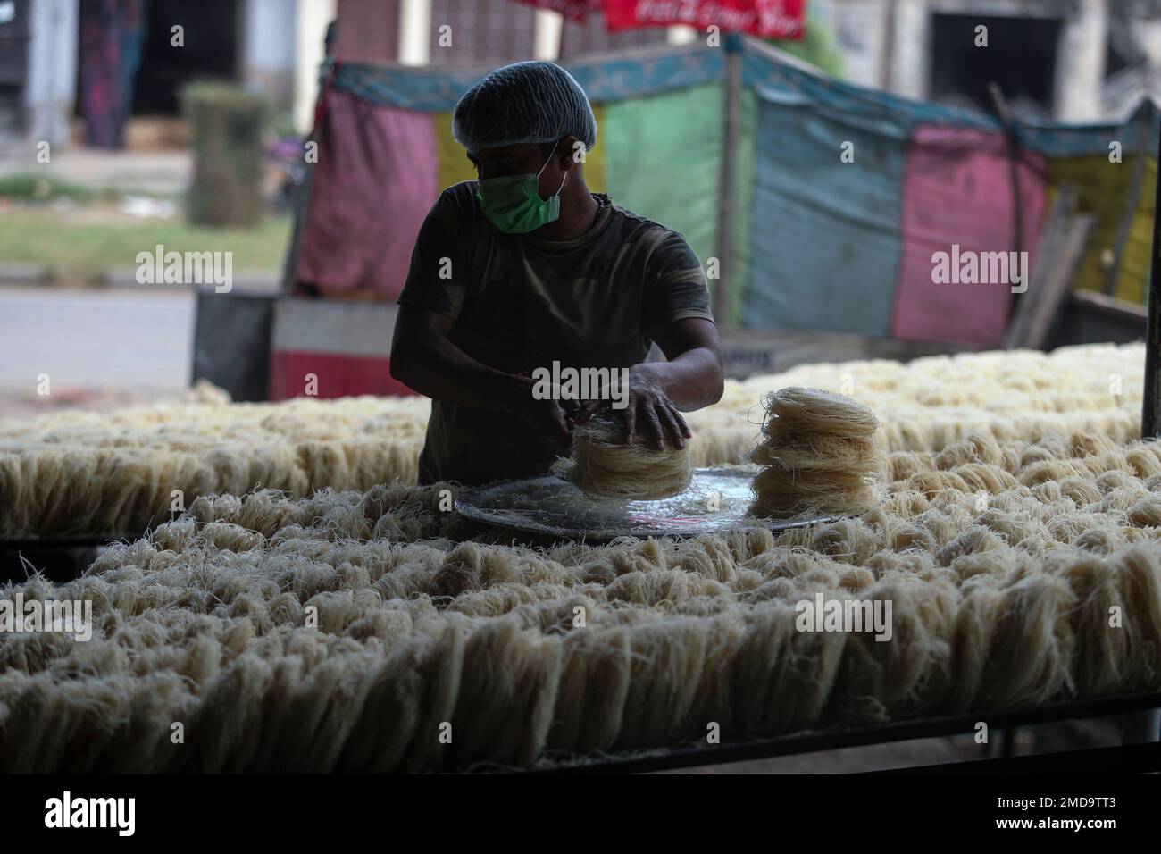 An Indian baker dries vermicelli to make a delicacy that is in demand ...