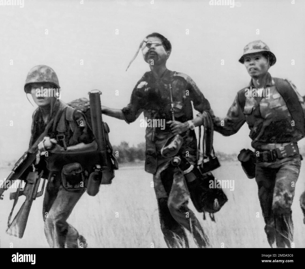 Associated Press photographer Dang Van Phuoc, center, is helped by ...